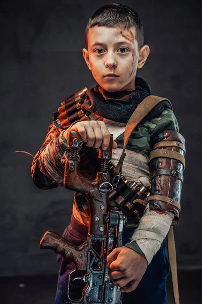 Armed with shotgun kid poses in dark background looking at camera Stock ...