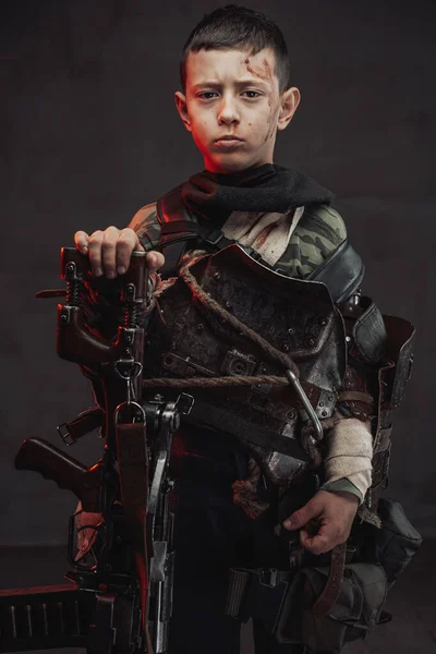 Armed with shotgun kid poses in dark background looking at camera Stock ...