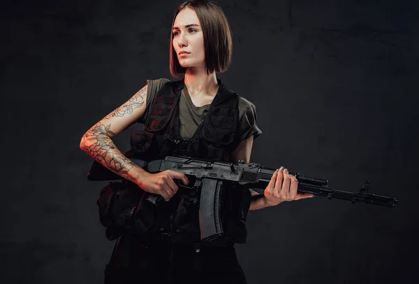 Cheerful female mercenary with assault rifle in dark background Stock ...