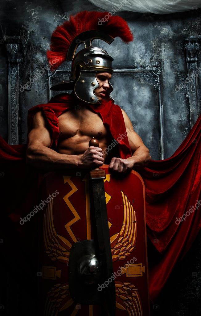 Roman good shaped warrior holds sword and schield — Stock Photo ...