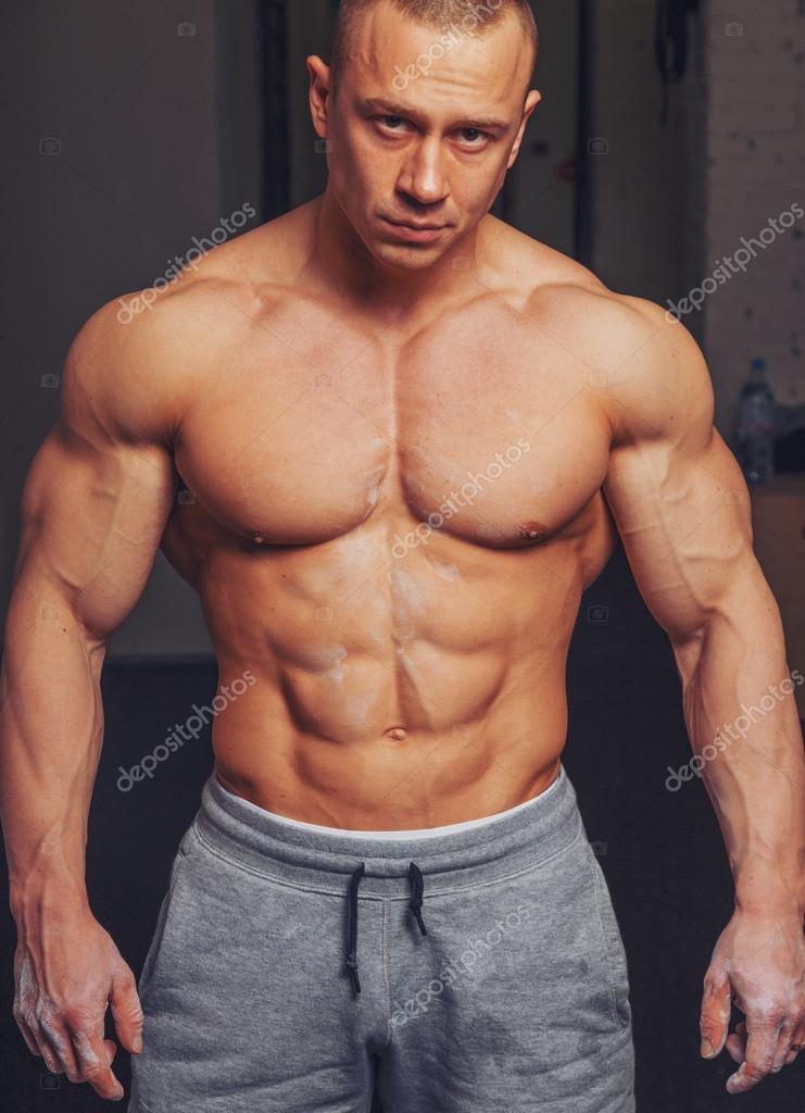 Bodybuilder poses and shows his muscles — Stock Photo © fxquadro #66924955