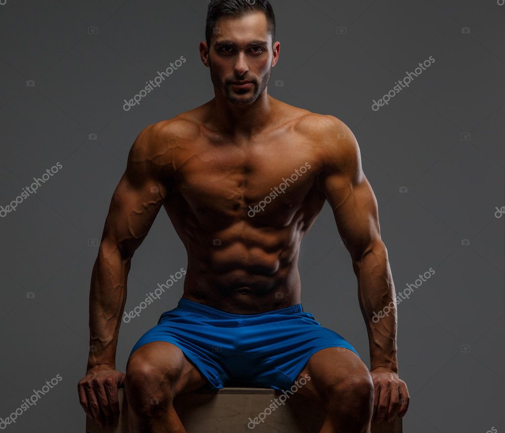 Shirtless muscular man on grey background Stock Photo by ©fxquadro 72921197