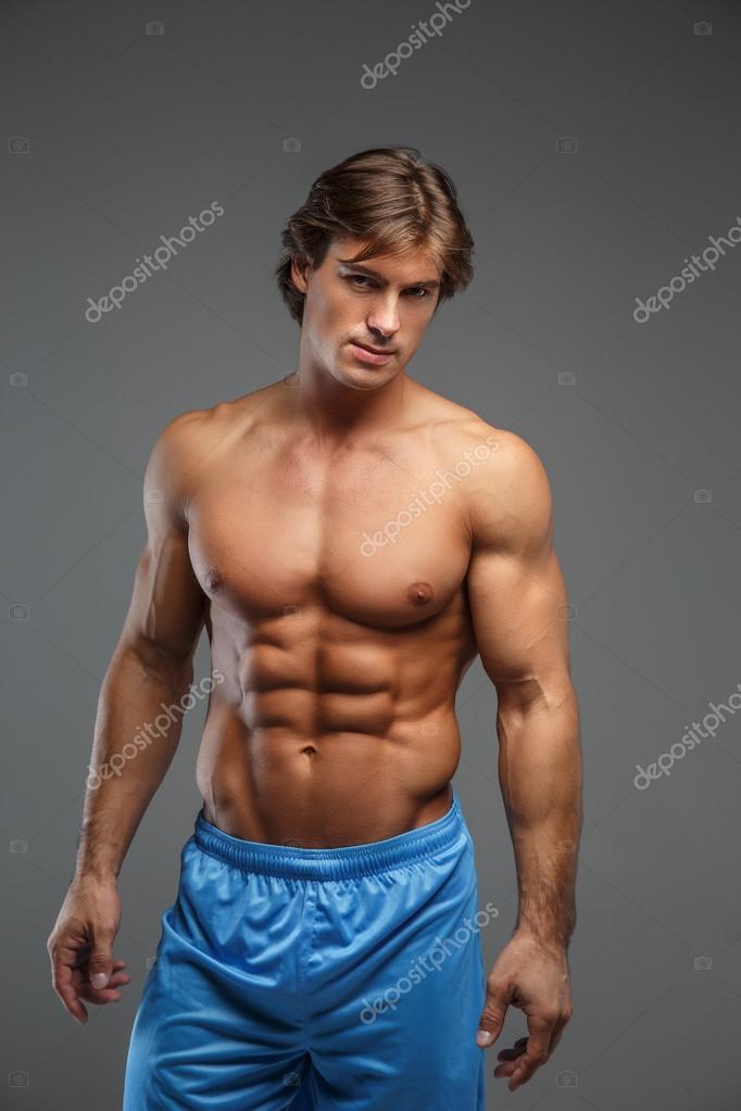Strong muscular man in blue shorts. — Stock Photo © fxquadro #86388020