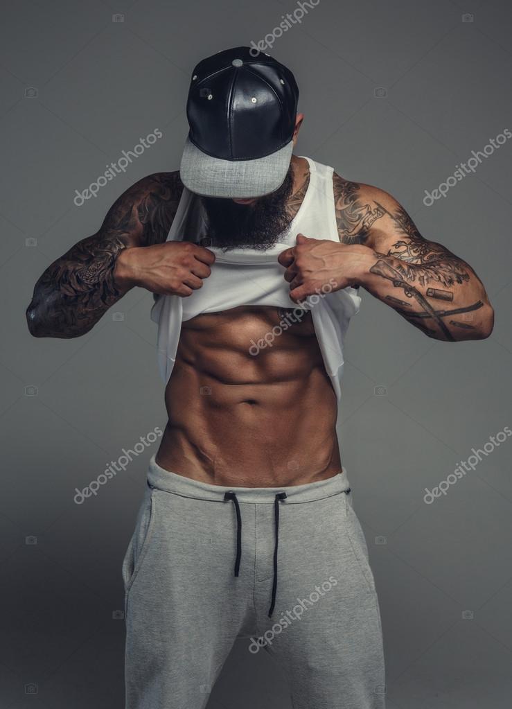 Muscular tattooed man with beard. Stock Photo by ©fxquadro 87313286