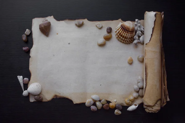 Old scroll of parchment with sea pebbles and seashells, nautical theme ...