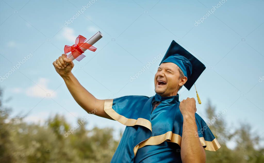 Un joven feliz hombre sonriente celebra su diploma de grado y doctorado ...
