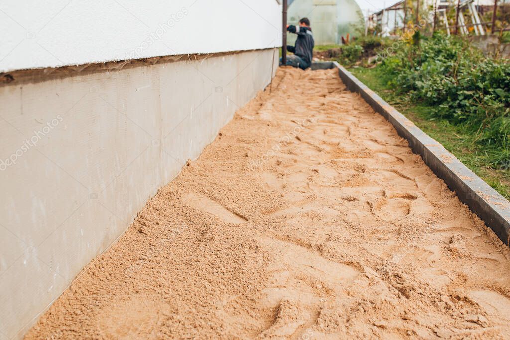 Construcción de un área ciega de una casa a partir de losas de ...
