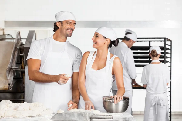 Bakers Looking At Each Other While Working In Bakery Stock Photo by ...