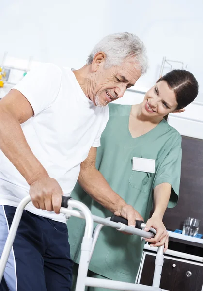 Young Nurse Helping Patient In Using Walker At Rehab Center - Stock ...