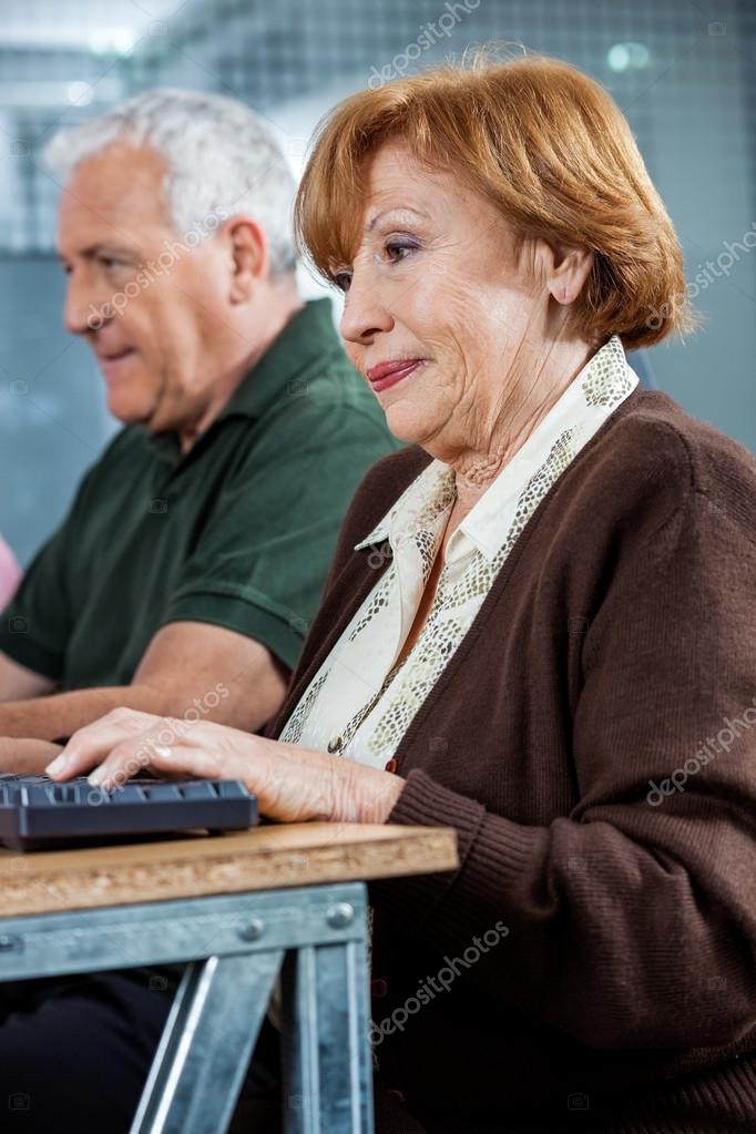 Confident Senior Students Using Computer In Classroom — Stock Photo ...