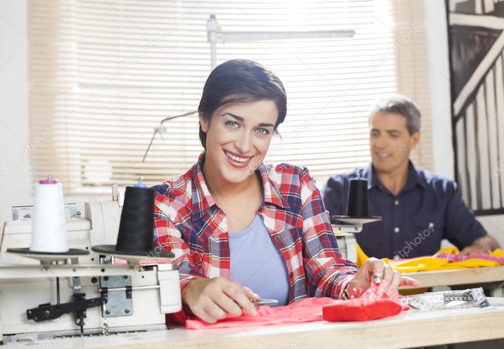 Happy Worker Sitting At Workbench In Sewing Factory Stock Photo by ...