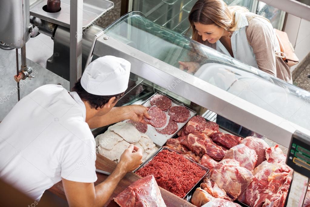 Butcher Showing Meat To Customer At Butchery — Stock Photo © SimpleFoto ...