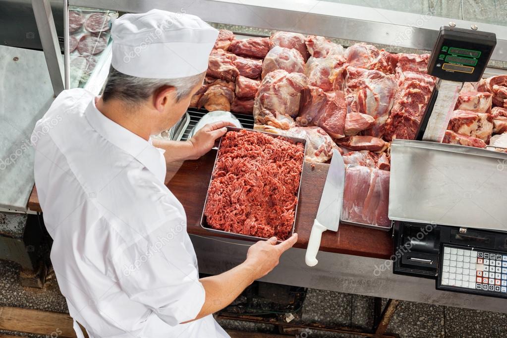 Butcher Holding Minced Meat Tray — Stock Photo © SimpleFoto #64659367