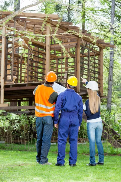 Architects Discussing Over Incomplete Timber Cabin At Site - Stock ...