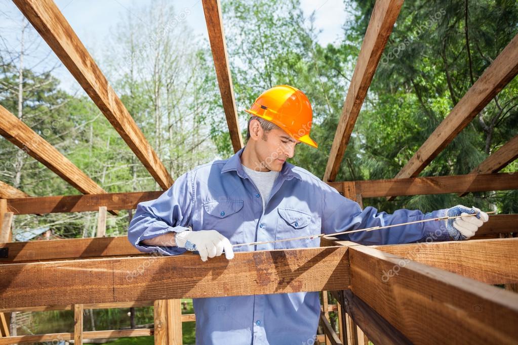 Construction Worker Measuring Timber Frame — Stock Photo © SimpleFoto ...