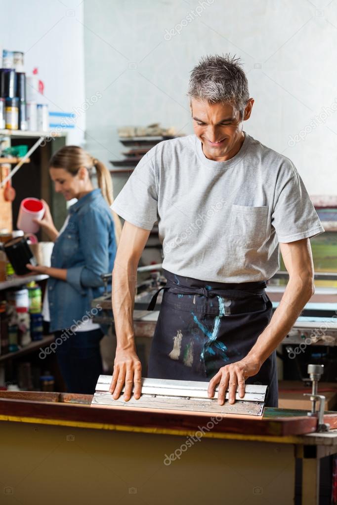 Man Using Squeegee While Colleague Working In Background Stock Photo by ...