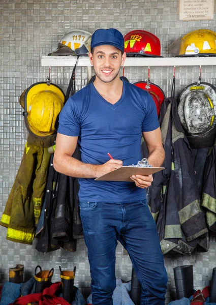 Confident Firefighter Holding Clipboard At Fire Station - Stock Image ...