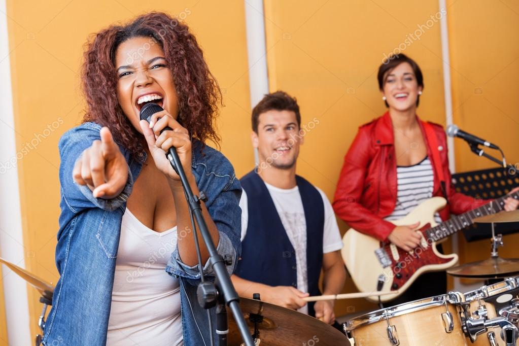 Female Singer Pointing While Performing In Recording Studio Stock Photo ...