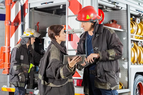 Firefighters Discussing Over Digital Tablet Against Truck - Stock Image ...