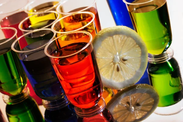 Multi-coloured alcohol shots and martini glass on white Stock Photo by ...