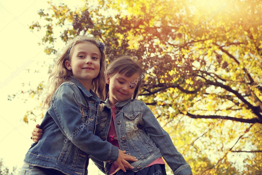 Two young girls having fun in the autumn sunny day Stock Photo by ...