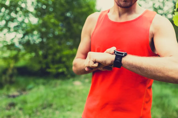 Runner looking at sport watch smartwatch - Stock Image - Everypixel