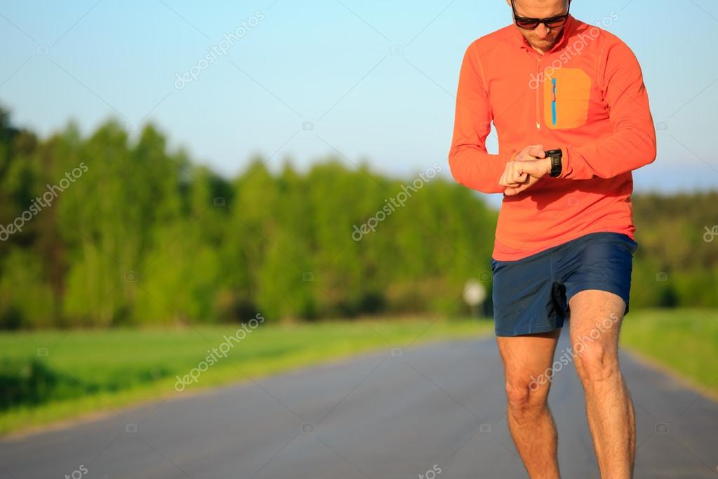 Runner training and checking stopwatch smart watch, cross countr ...