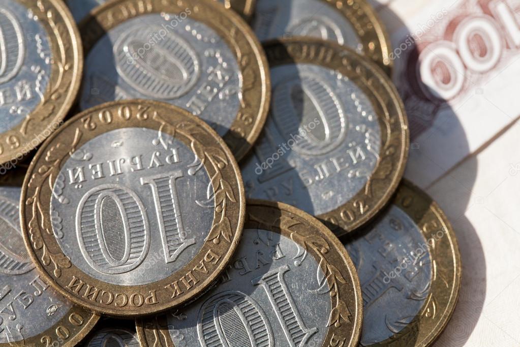 Moneda diez rublos en un papel de fondo notas por valor de cien rublos 2022