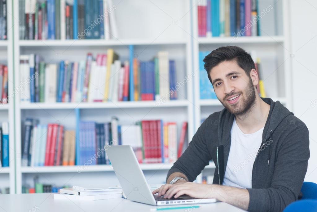 Student in school library using laptop for research Stock Photo by ...