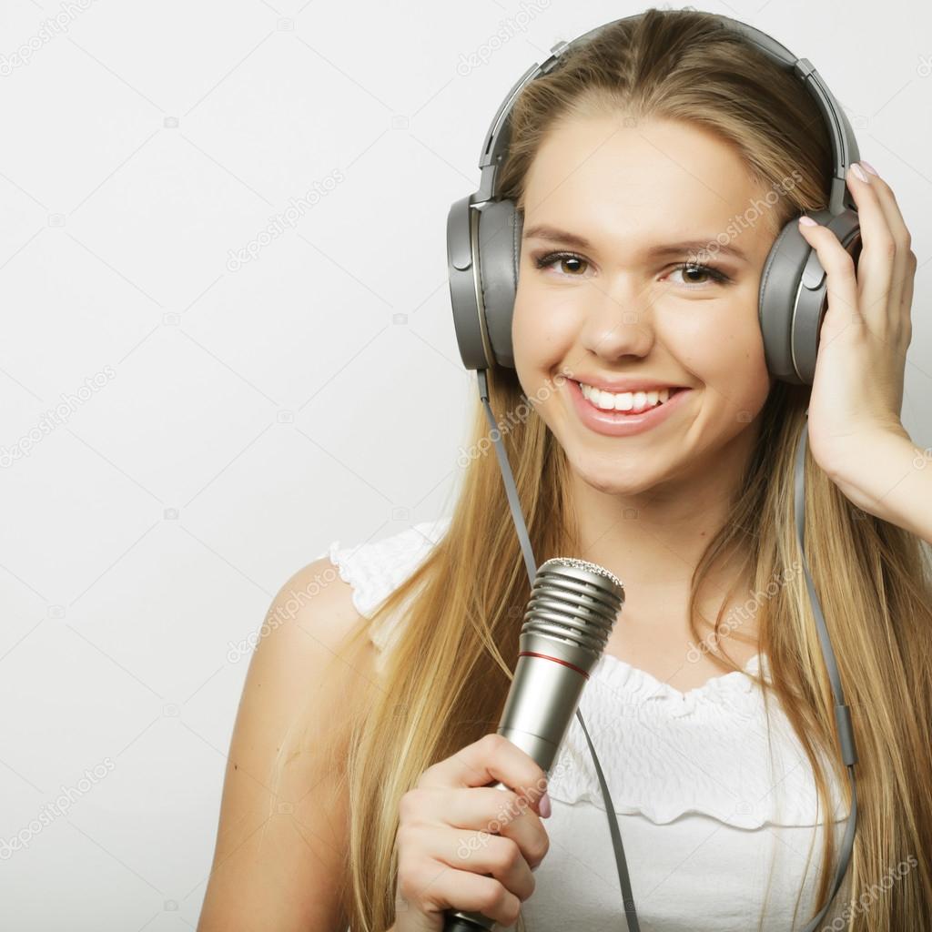 Beautiful young woman with microphone and headphones Stock Photo by ...