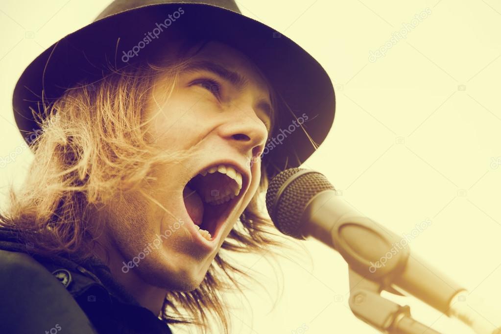 Young man shouting to microphone. — Stock Photo © Photocreo #68398991