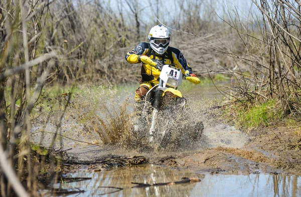 Enduro motorcycle rides through the mud with a big splash - Stock Image ...