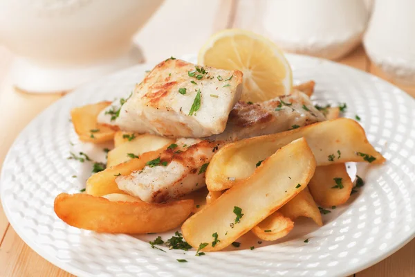 Cod fish steak with fried potato and lemon — Stock Photo © igordutina ...