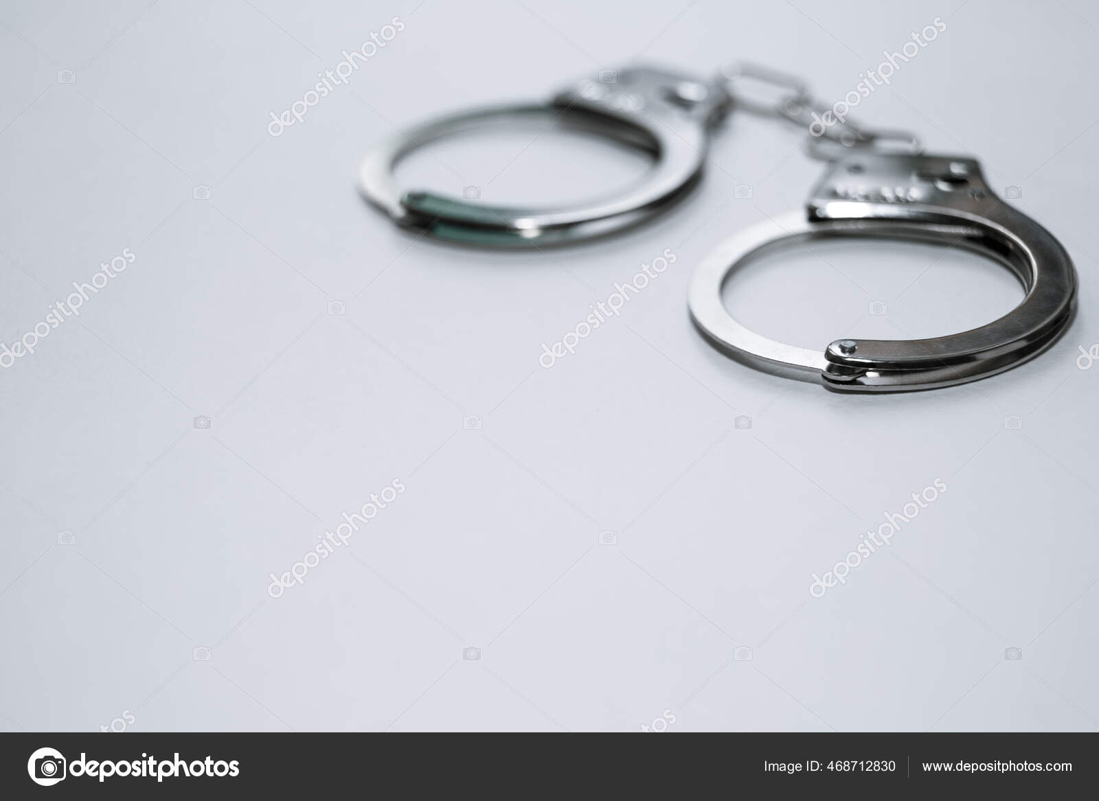 Handcuffs on a white background in the upper left corner of the frame ...