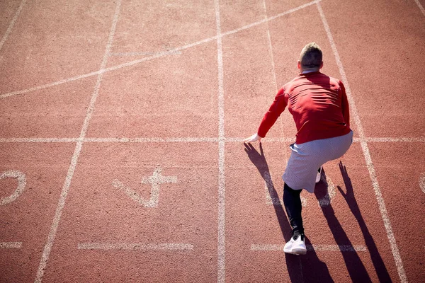 image from above of a man on start line, ready to start running on ...