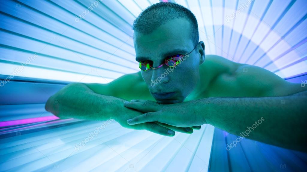 Handsome man in tanning booth Stock Photo by ©luckybusiness 87143004