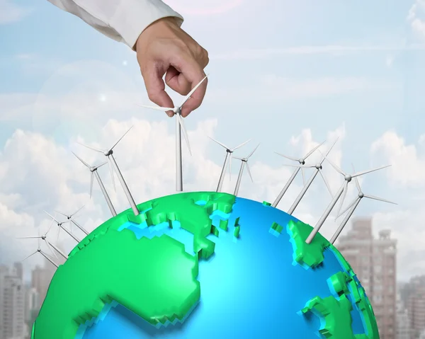 Human hand holding wind turbine on globe Stock Photo by ©bruesw 100850356