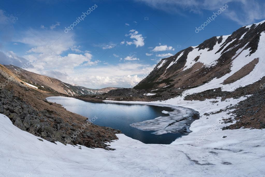 Mountain lake with ice and snow in spring Stock Photo by ©Kotenko 118632042