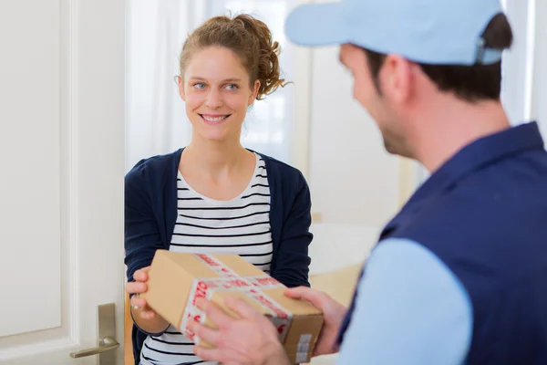 Delivery man handing over a parcel to customer - Stock Image - Everypixel