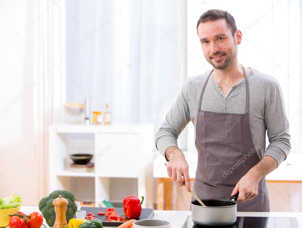 Joven hombre atractivo cocinando en una cocina: fotografía de stock ...