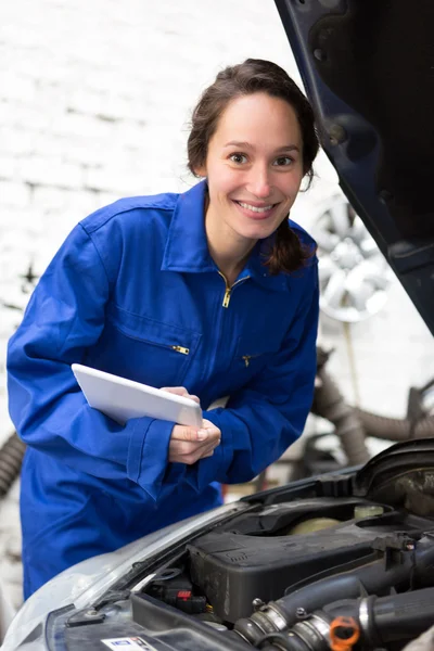 Young attractive woman mechanic working at the garage - Stock Image ...