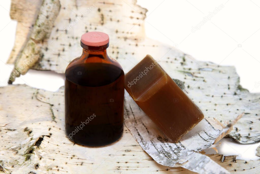 Alquitrán líquido en una botella y un pedazo de jabón de alquitrán ...