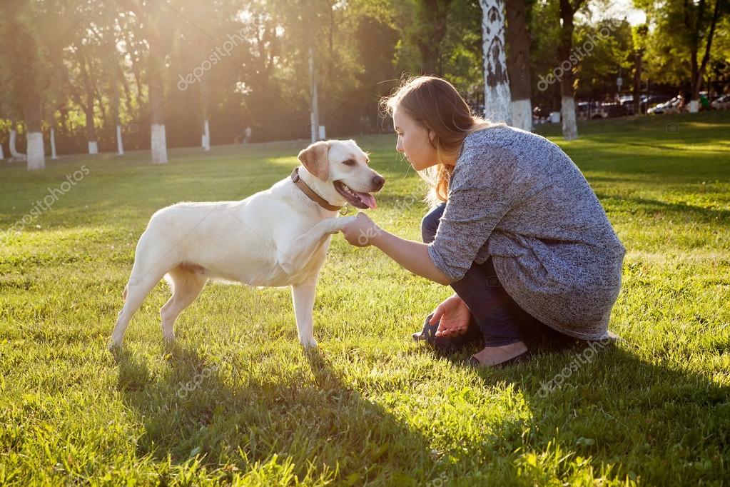 Hermosa mujer jugando con su perro . — Foto de stock #77136283 © bezzznika