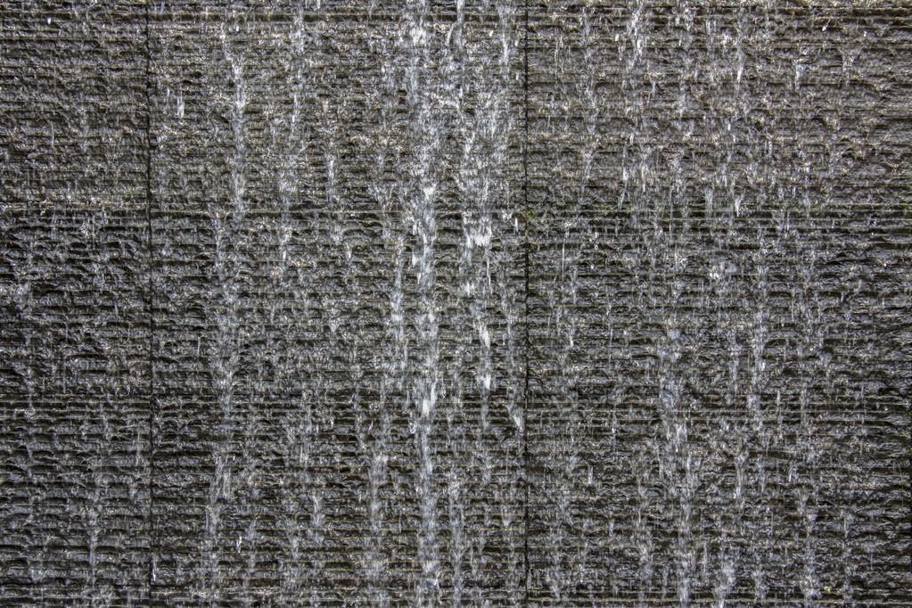 Flowing sheet water from the artificial waterfall along the rough ...