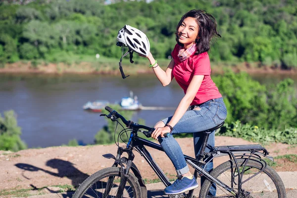 Bike helmet - woman putting biking helmet on during bicycle ride ...