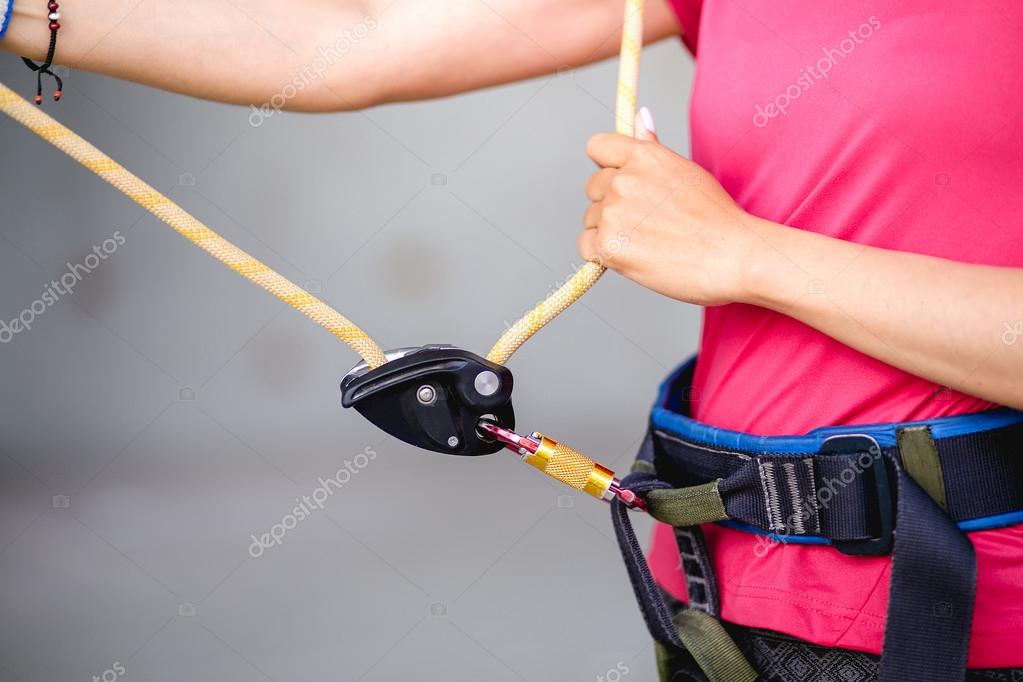 Climbing gear and rope attached to a female climber's harness Stock ...