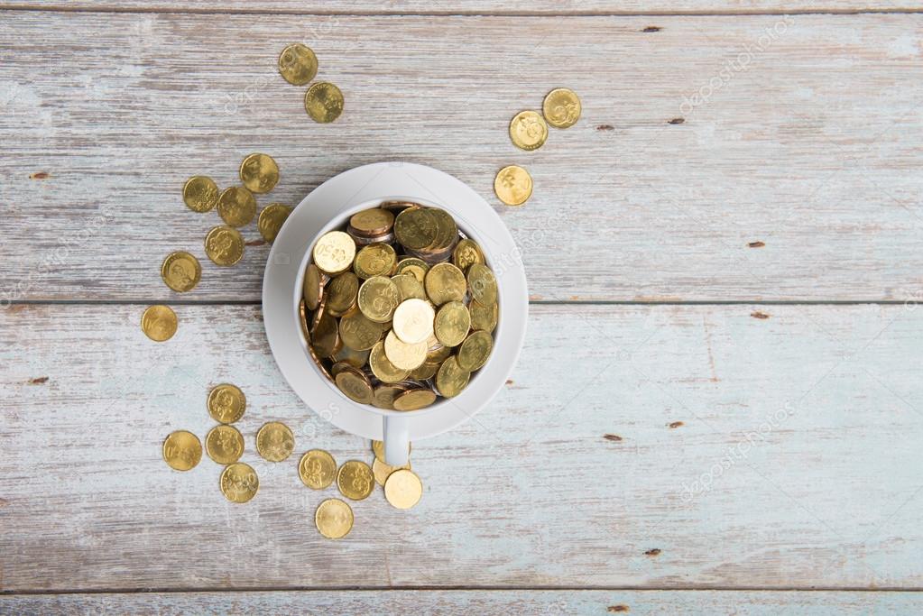 Coffee cup with gold coins Stock Photo by ©yuliang11 101307286