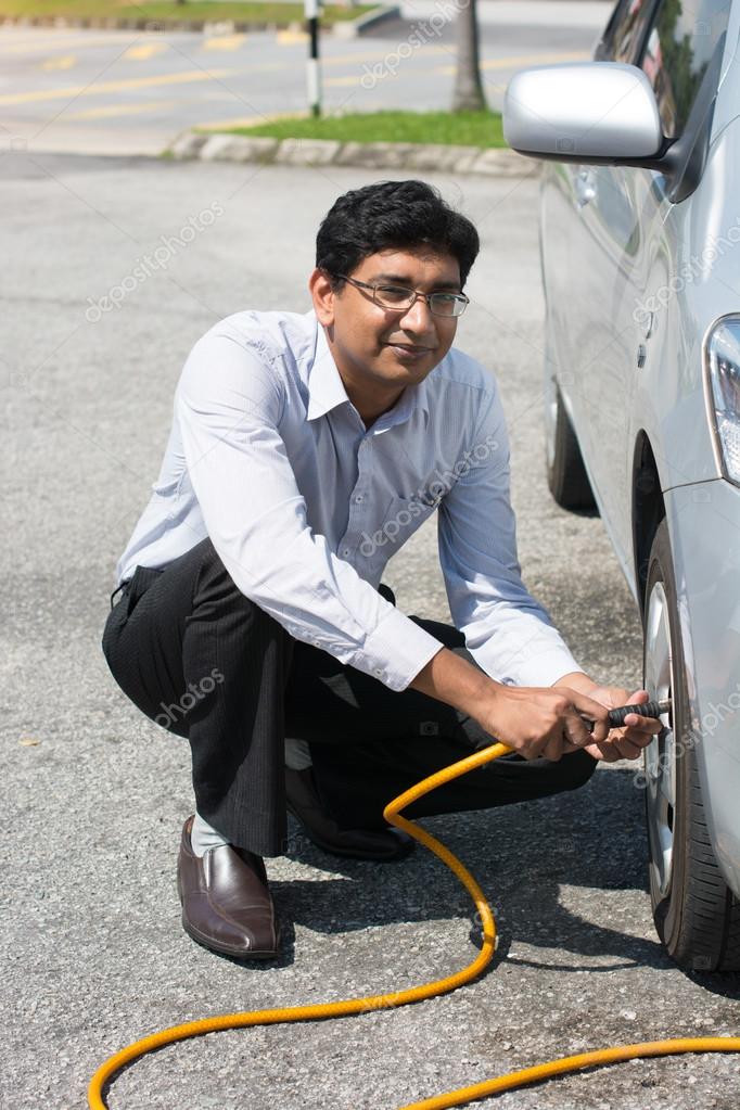 Man pumping air at station Stock Photo by ©yuliang11 105795580