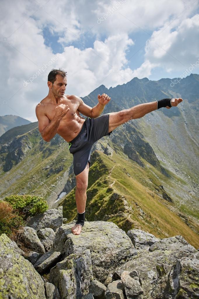 Kickboxer Shadow boxing on mountains Stock Photo by ©Xalanx 85077714