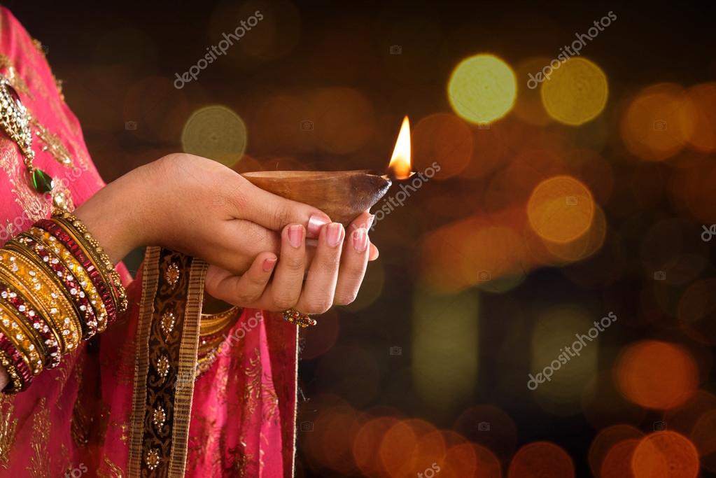 Close up Indian woman hands holding diya light — Stock Photo © szefei ...